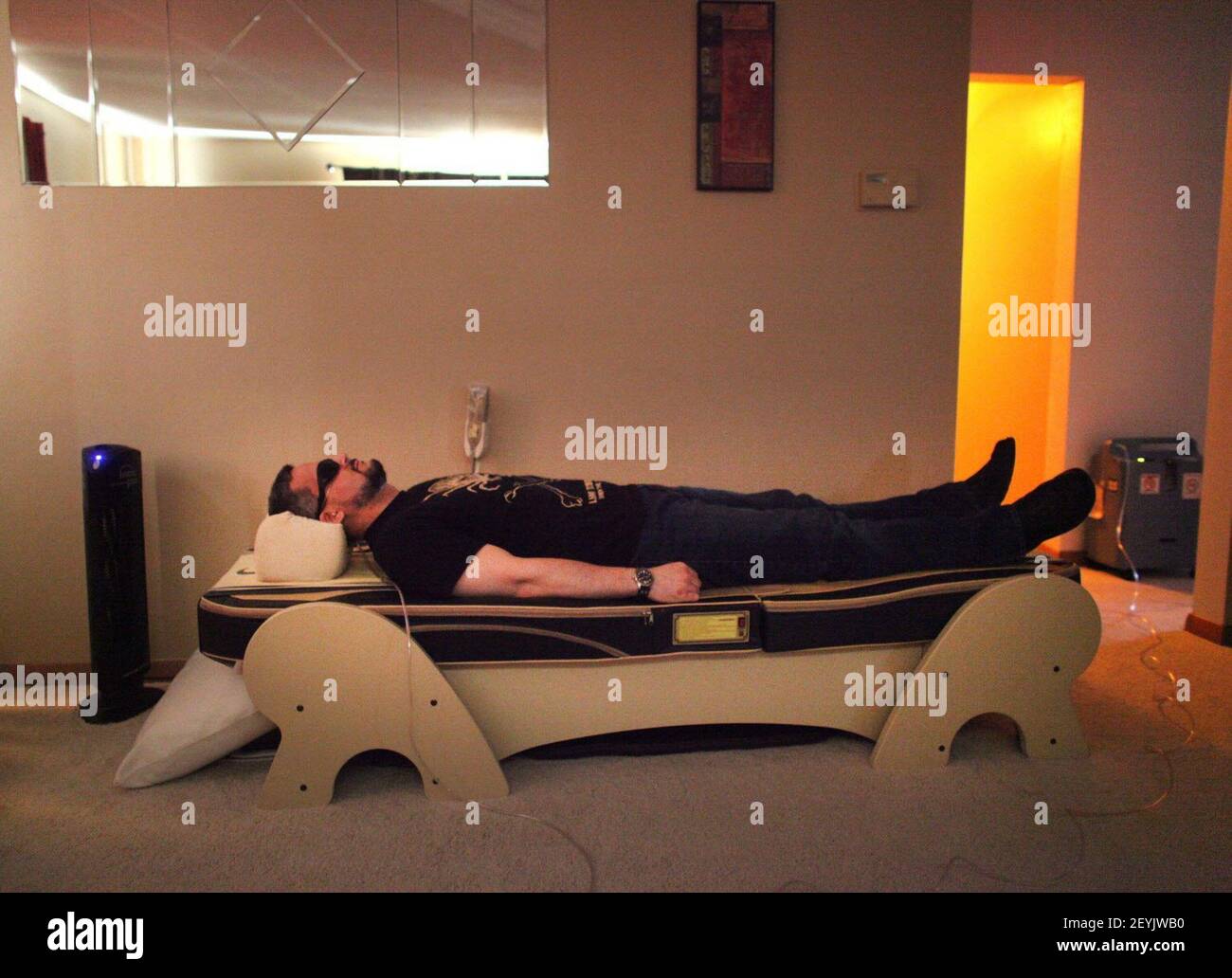 Nathan Braatz lies on his therapy bed, which massages his muscles ...