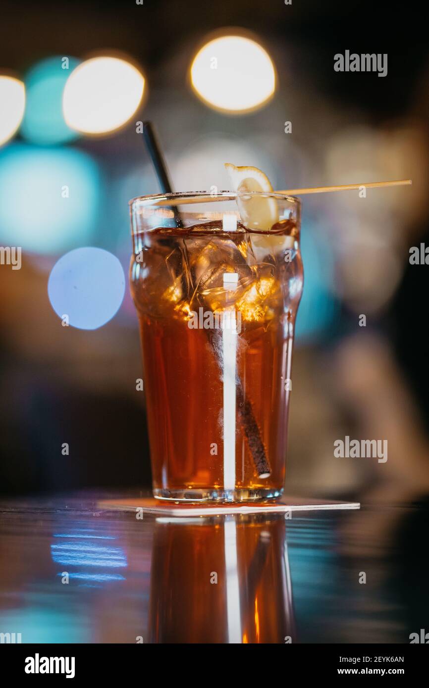 A vertical shot of a refreshing drink with a lemon slice on blurred ...