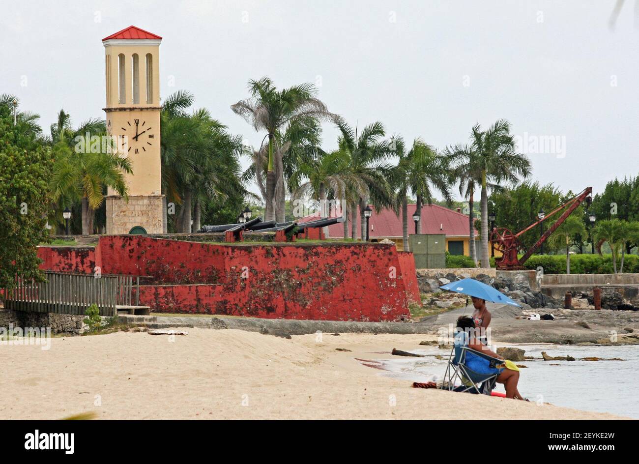 Beachgoers watch the surf from their chairs next to Fort Frederik in ...