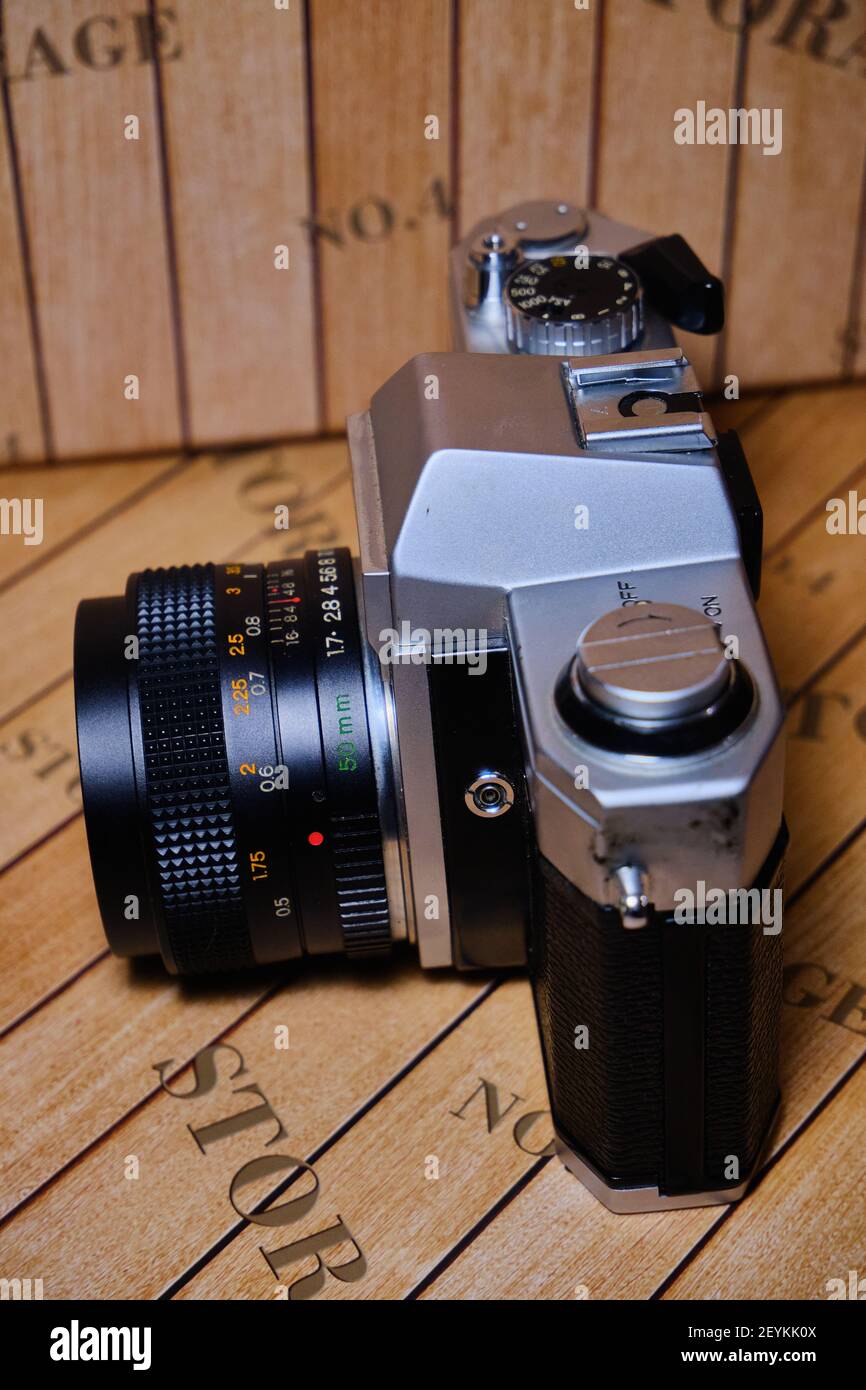 A vertical shot of a vintage camera on a wooden surface with storage ...