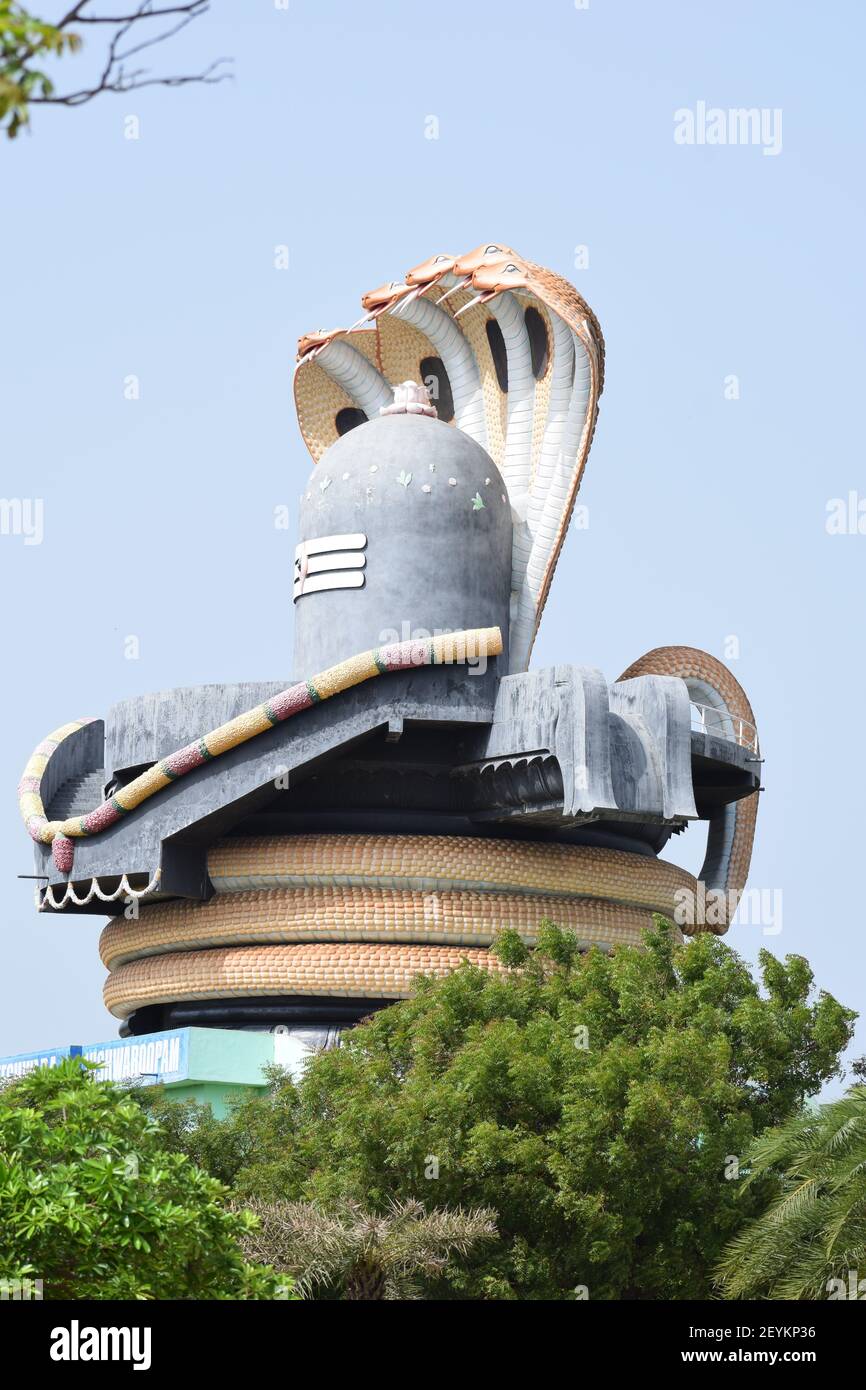 A vertical shot of a building with huge snake sculptures under a clear ...
