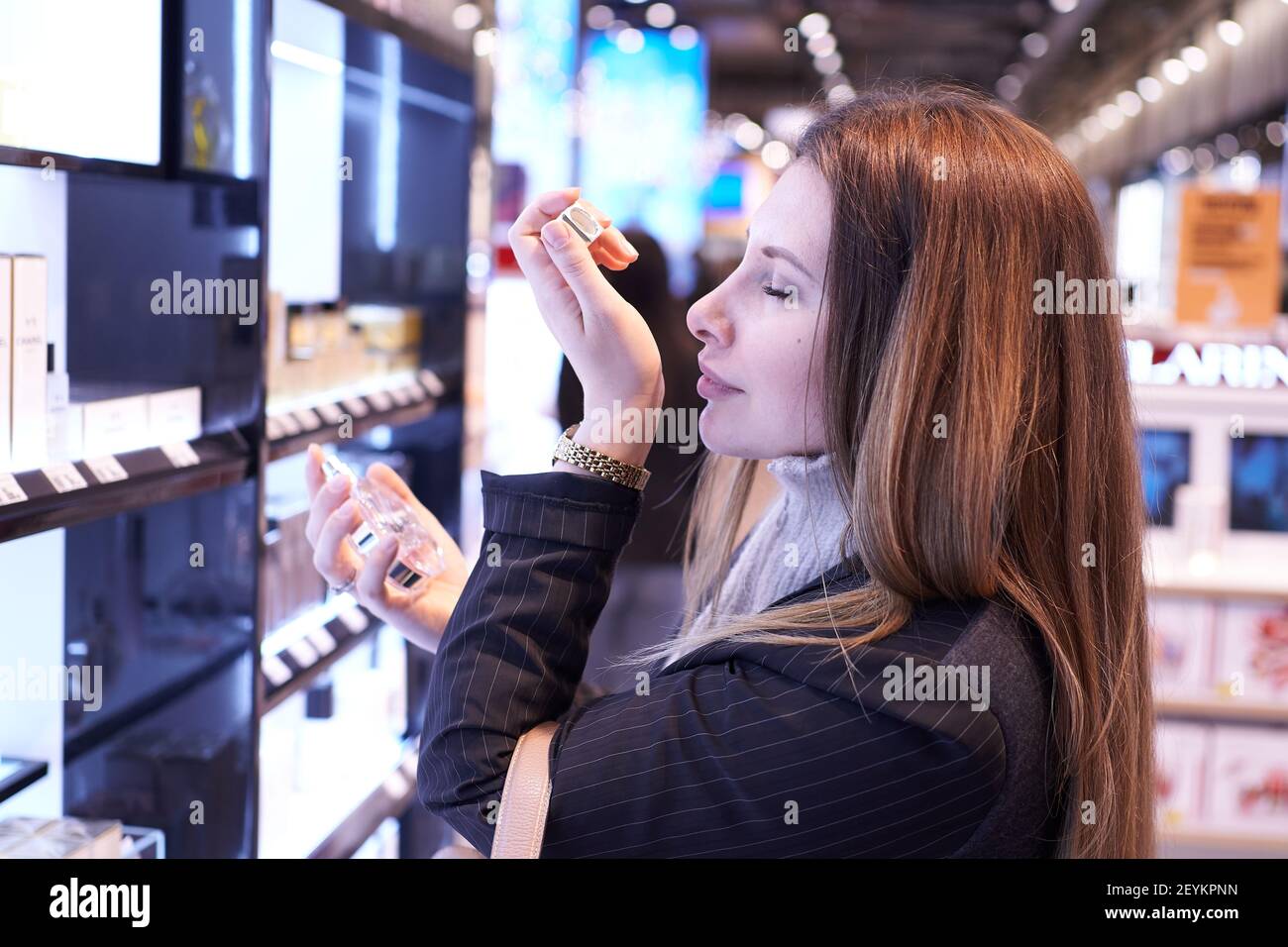 beautiful girl chooses perfume in a cosmetic store Stock Photo - Alamy