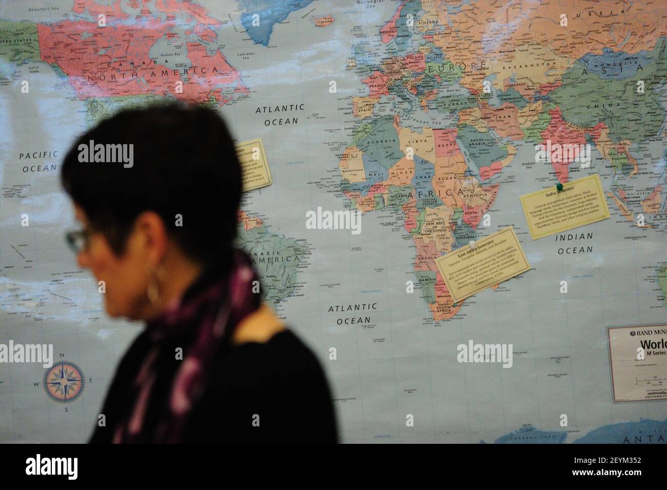 A woman walks past a map of the world at Carpe Mundi's annual auction ...