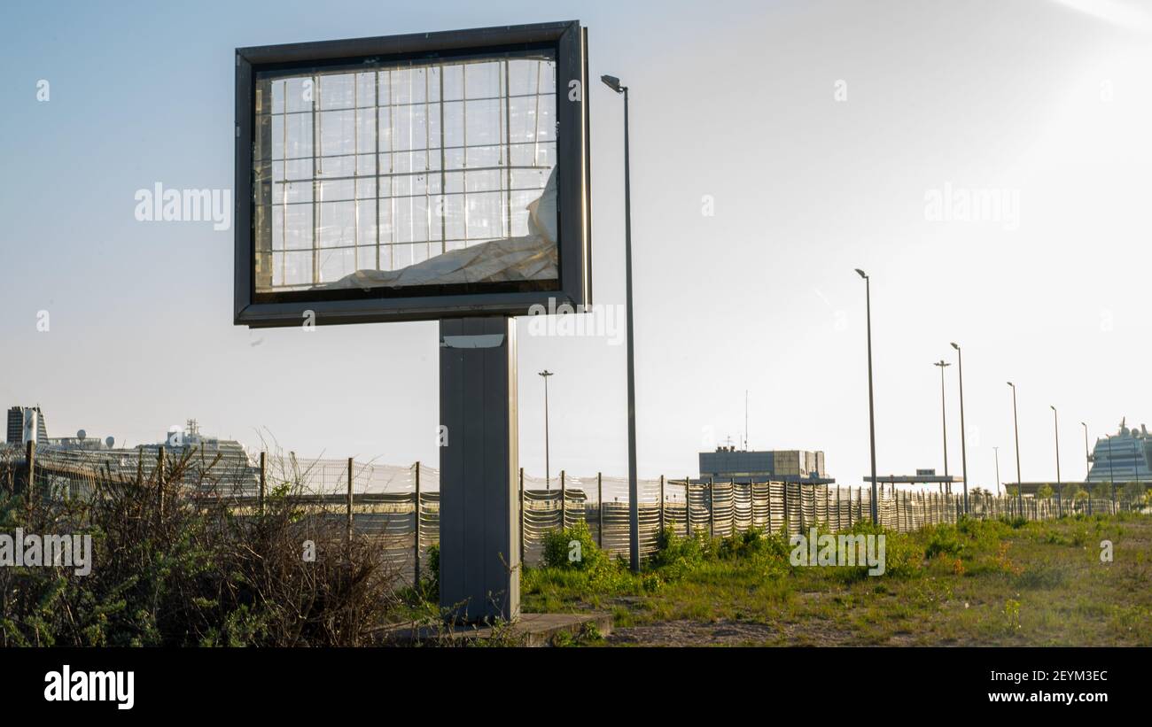 A large blank dirty billboard with torn canvas and the space for ad in ...