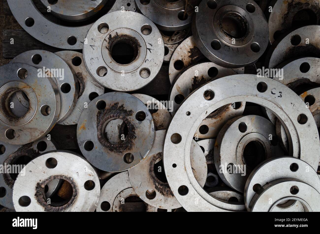 New and used flanges rusty and clean shiny Stock Photo - Alamy