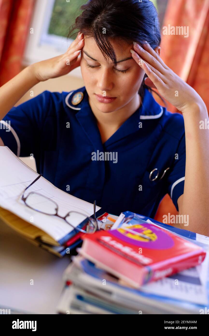 Nurse looking tired as she revises for exams Stock Photo - Alamy