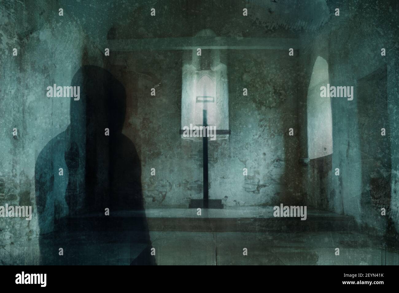 A horror concept, of a hooded figure silhouetted against a cross in an ...