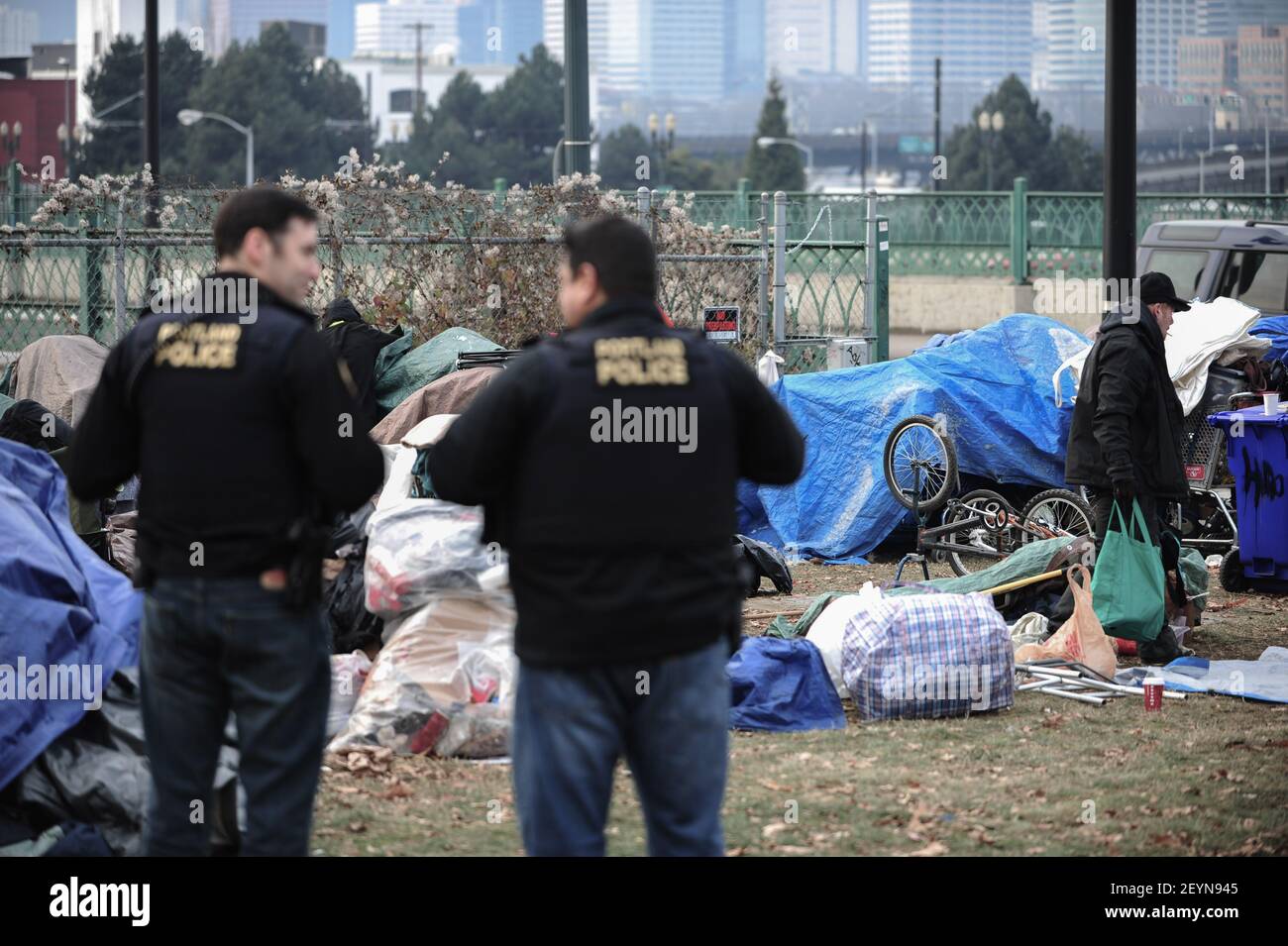 Police officers observe as homeless campers pack up their belongings ...