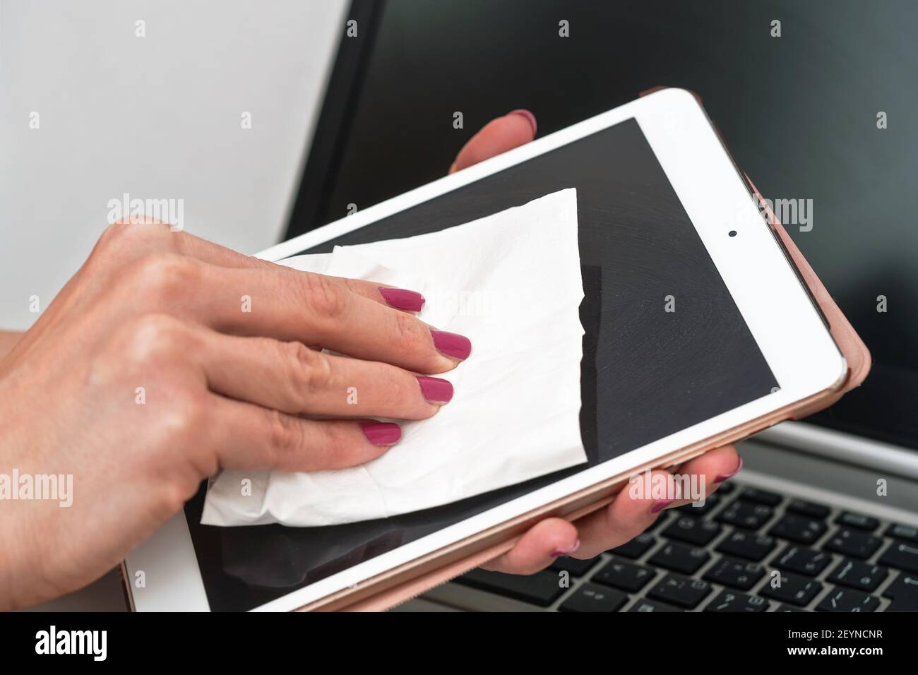 Woman cleaning tablet device with cotton paper tissue, wiping black ...