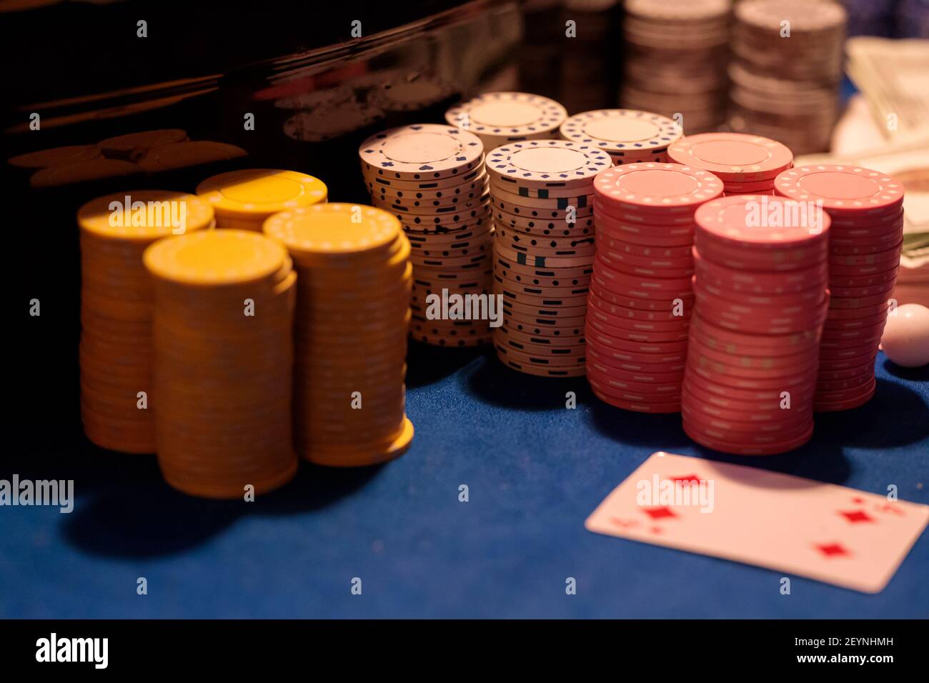 Casino betting chips stacked up next to playing card Stock Photo - Alamy
