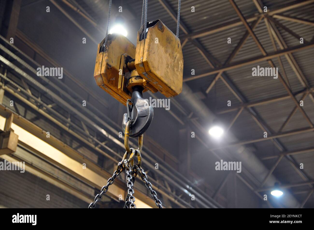 Lifting mechanism in the workshop at the plant. Crane hook and chains ...