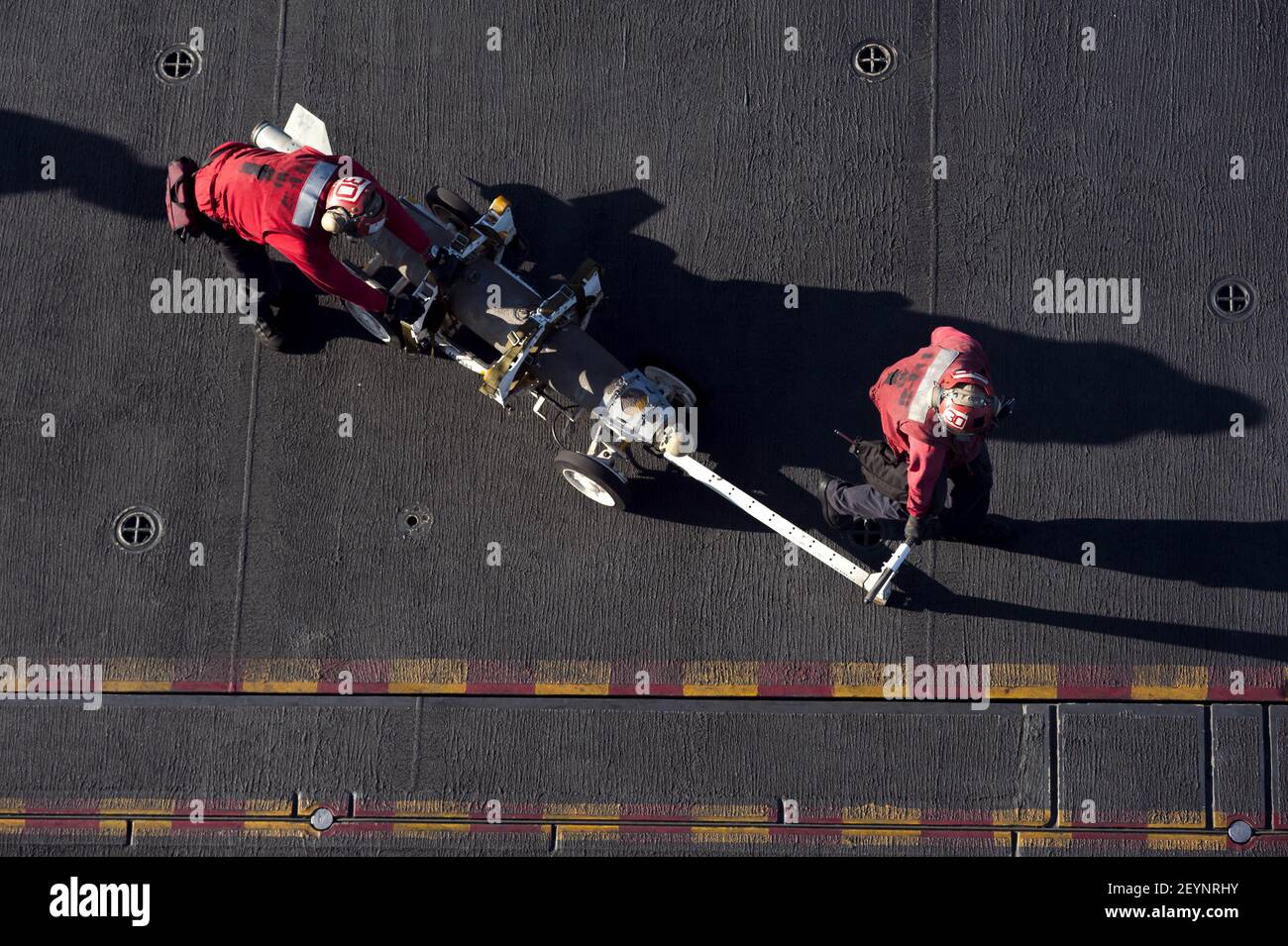 U.S. Navy aviation ordnancemen transport a GBU-38 joint direct attack ...
