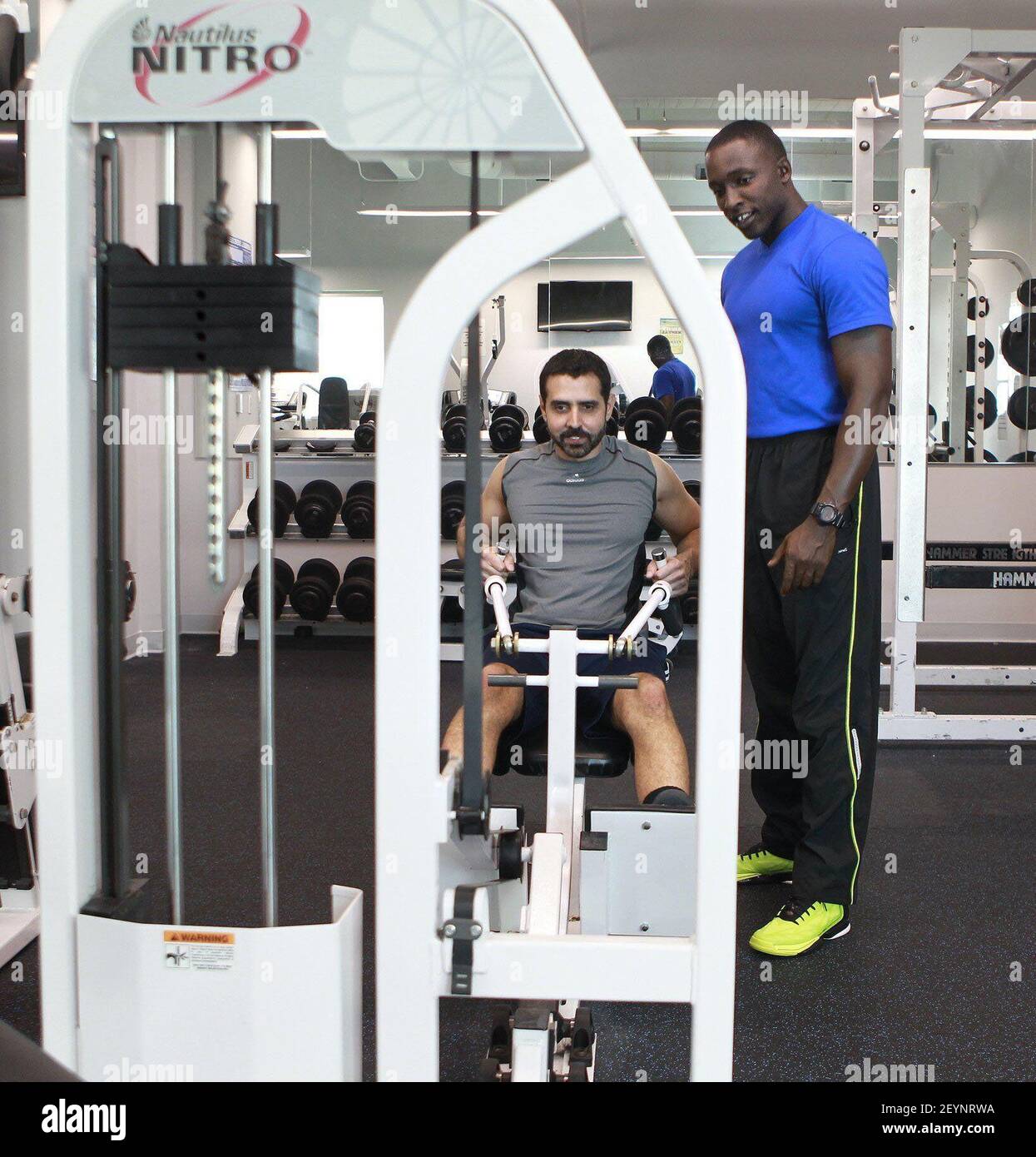 Fitness instructor Jeff Pierre watches over as Eddie Alvarez performs a ...