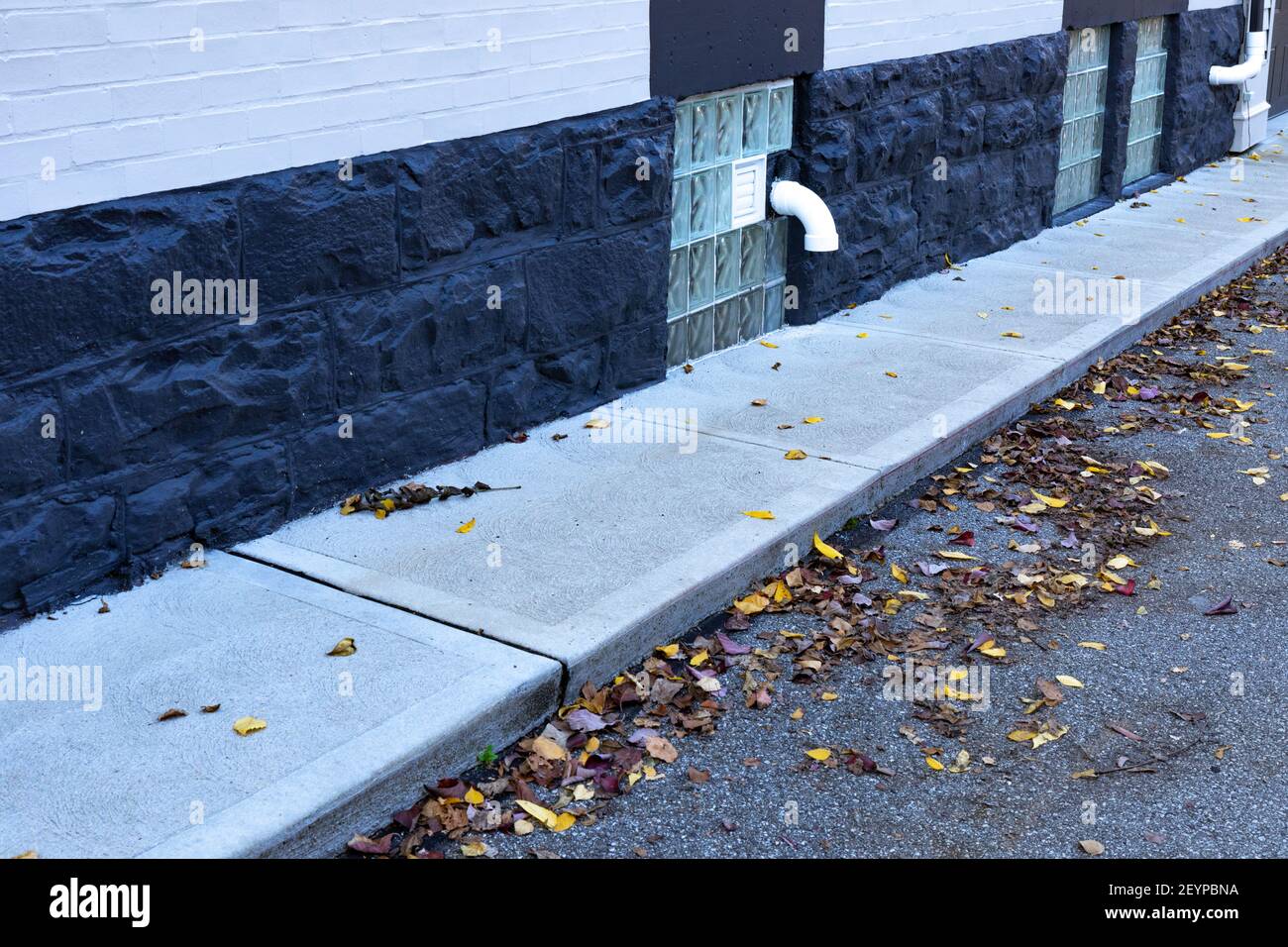 Narrow sidewalk between building and street, glass block windows ...