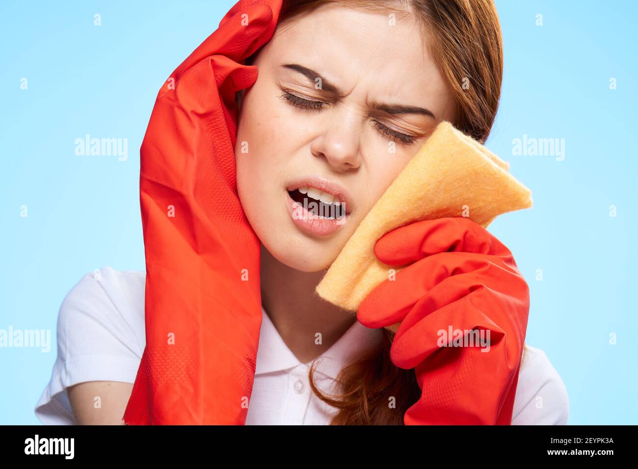cleaning lady in rubber gloves holding a rag near face lifestyle blue ...