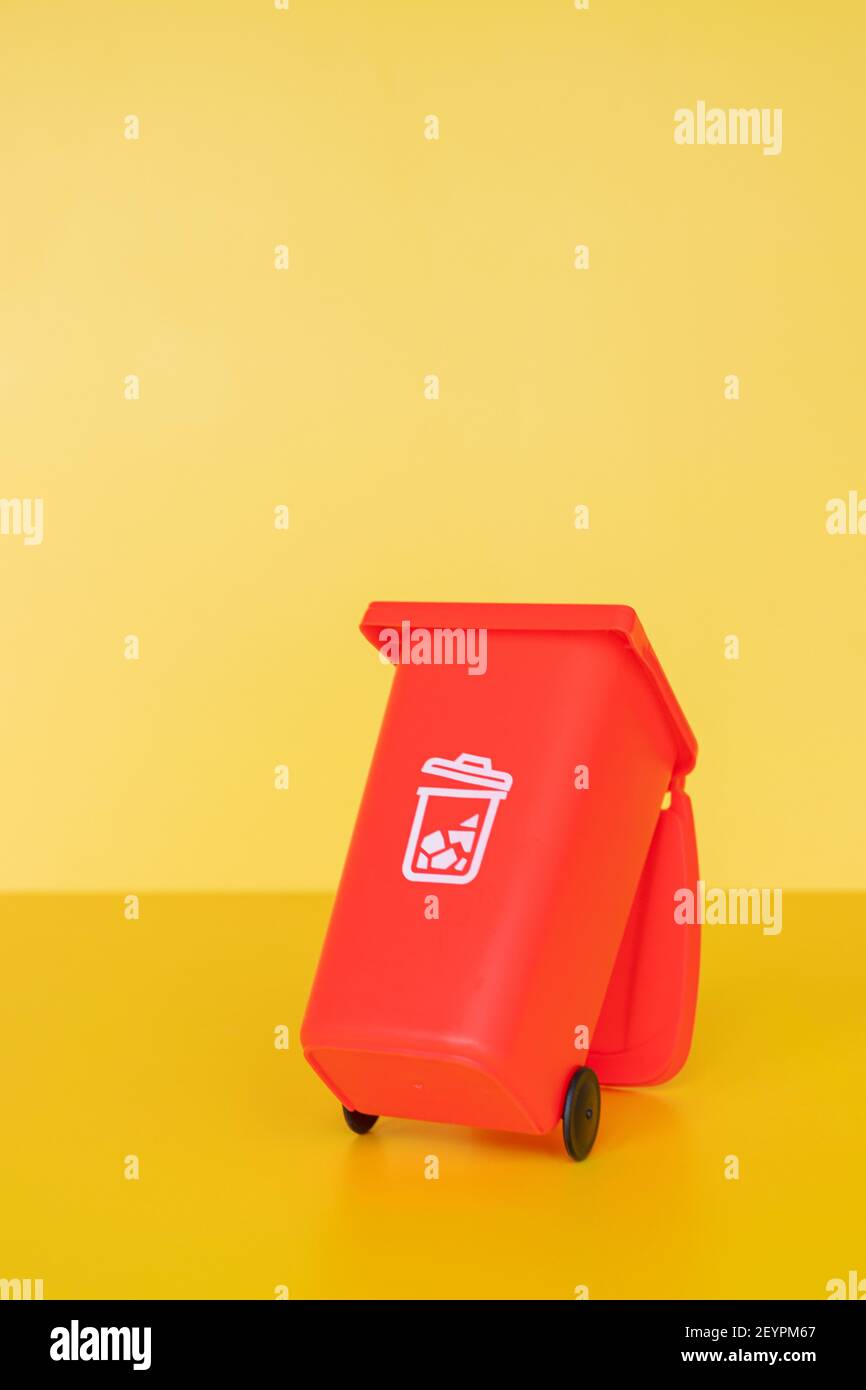 Red garbage container on yellow background Stock Photo - Alamy