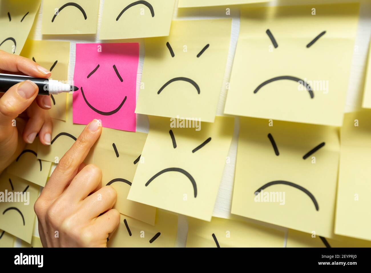 A business woman's hand draws a positive face on a sticky note Stock ...