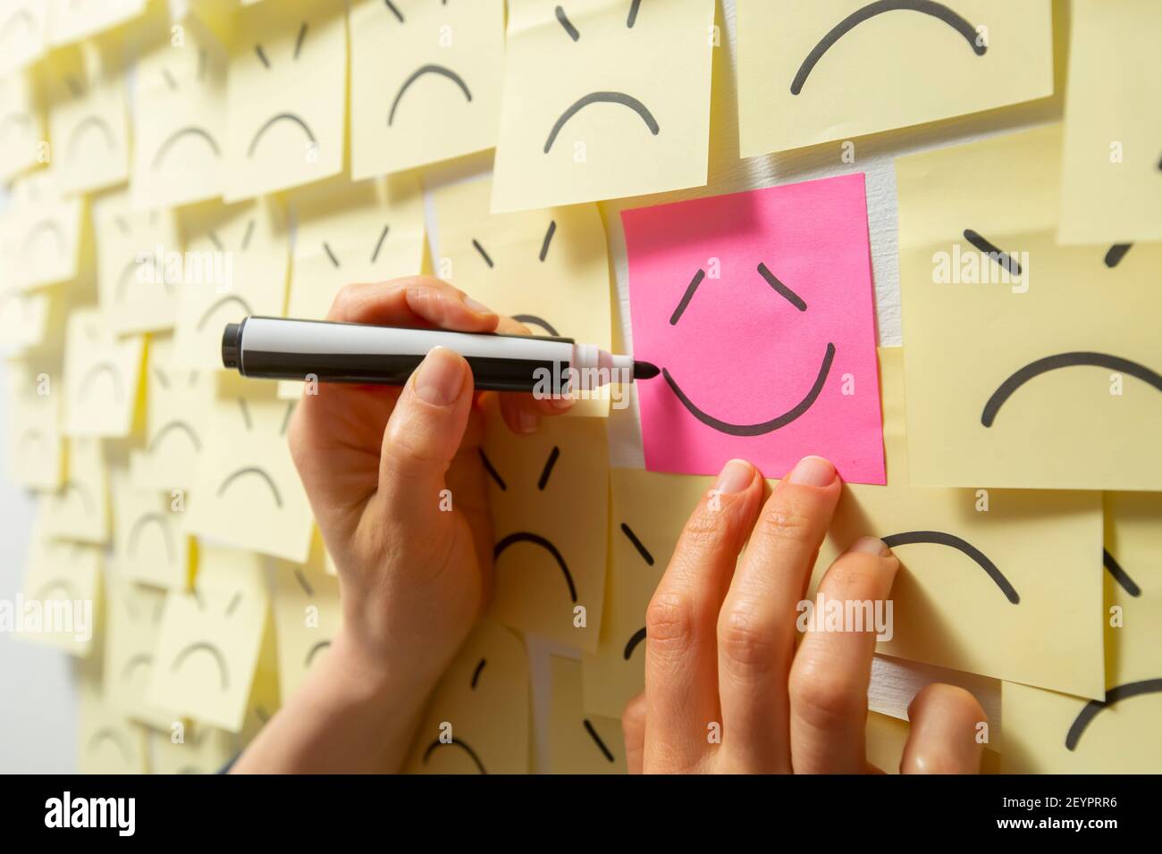 A business woman's hand draws a positive face on a sticky note Stock ...