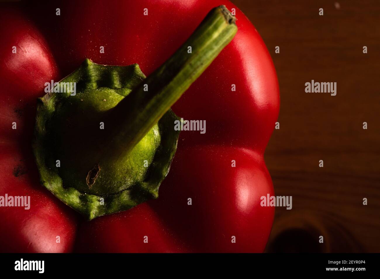 closeup of a red bell pepper with dark shadows emphasizing the ...