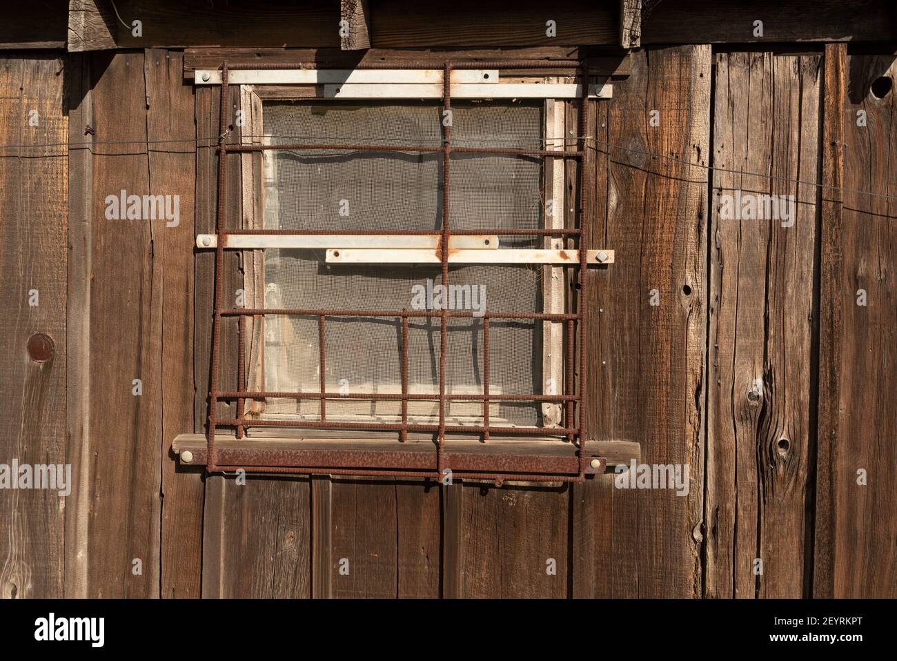 Old rusty bars on old wooden house window, illustrating the concept of ...