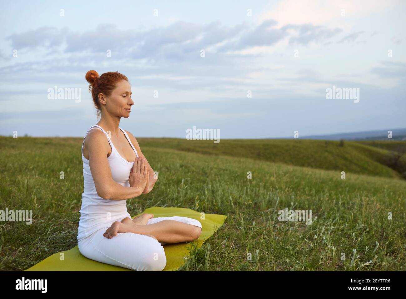 Adult female meditating in summer spring hills Stock Photo - Alamy