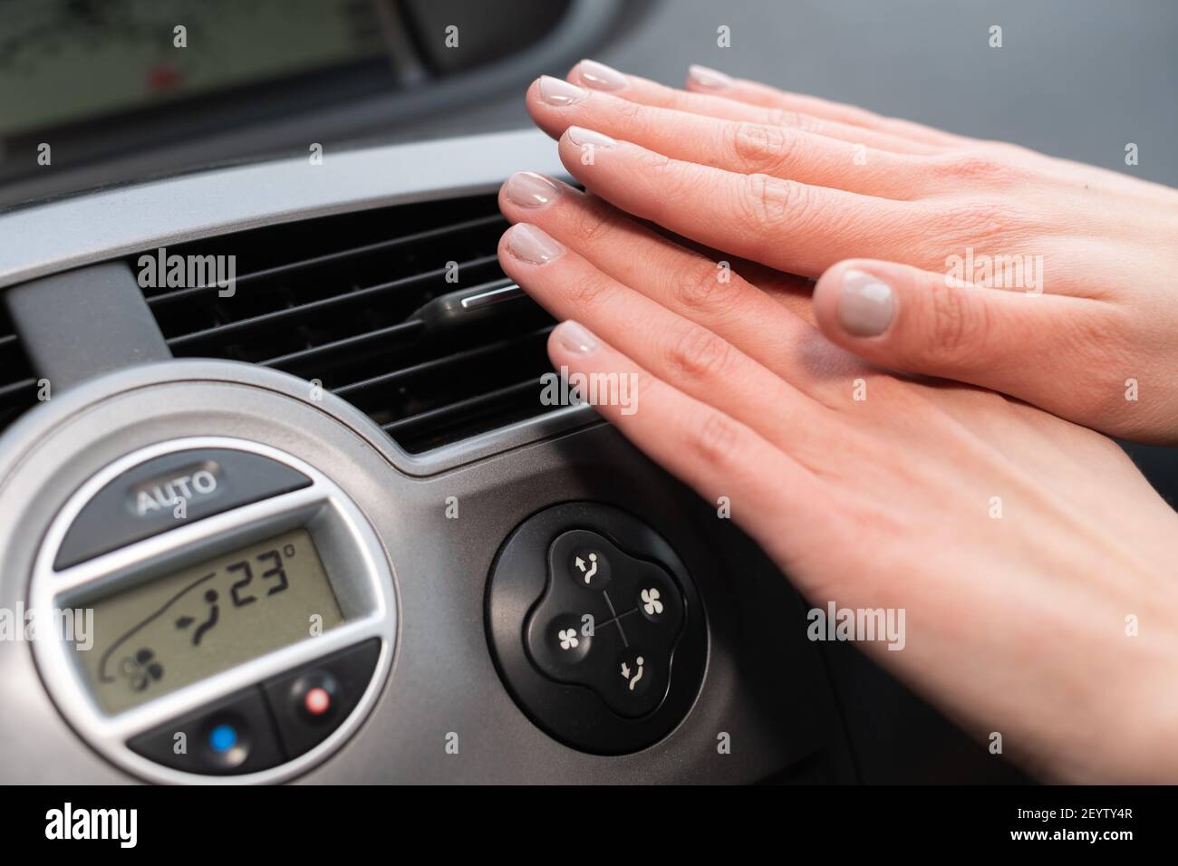 The girl holds her hands cold over a car heater. Hot air Stock Photo ...