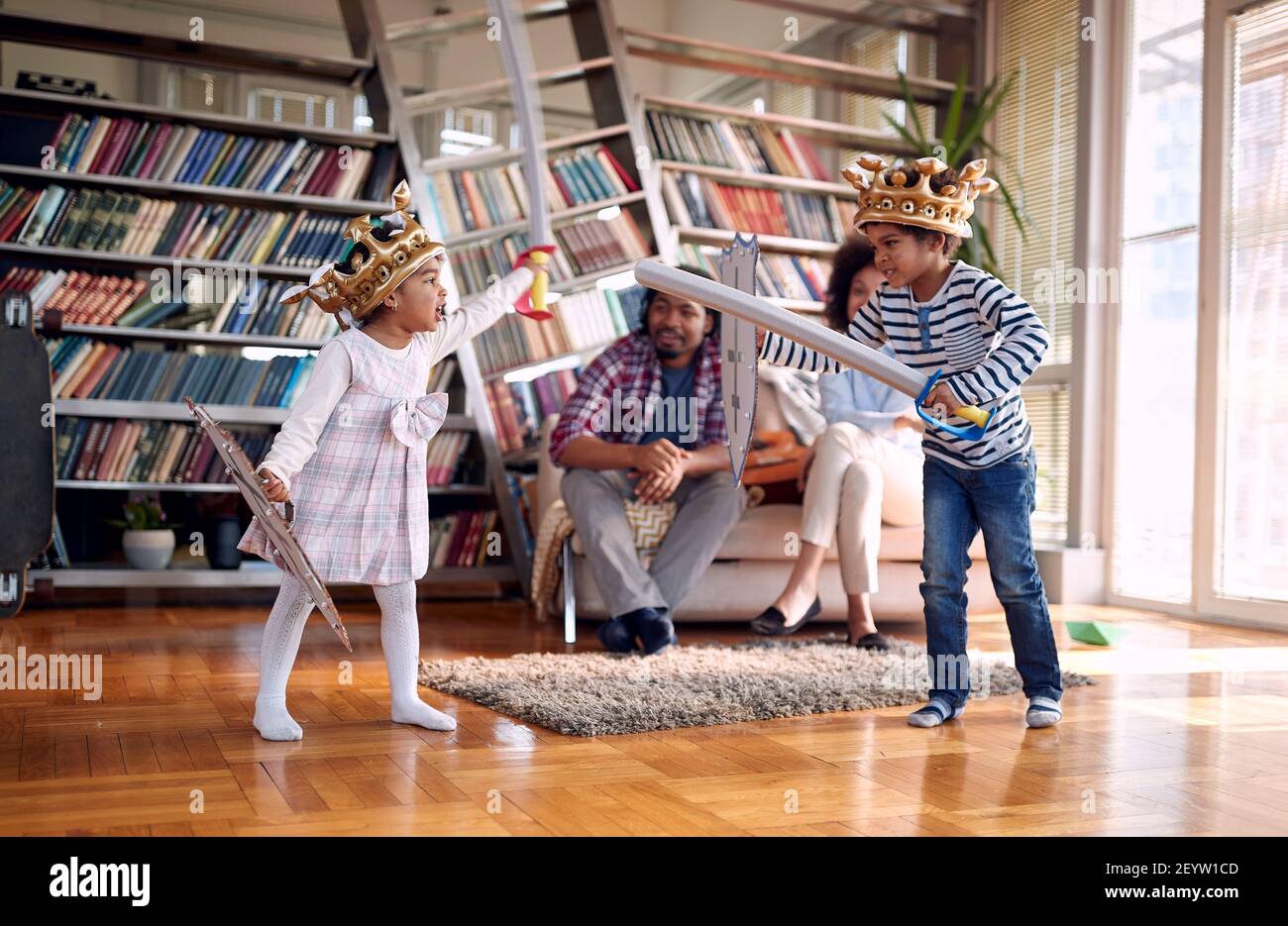 Kids playing with swords and enjoying with parents in a cheerful ...