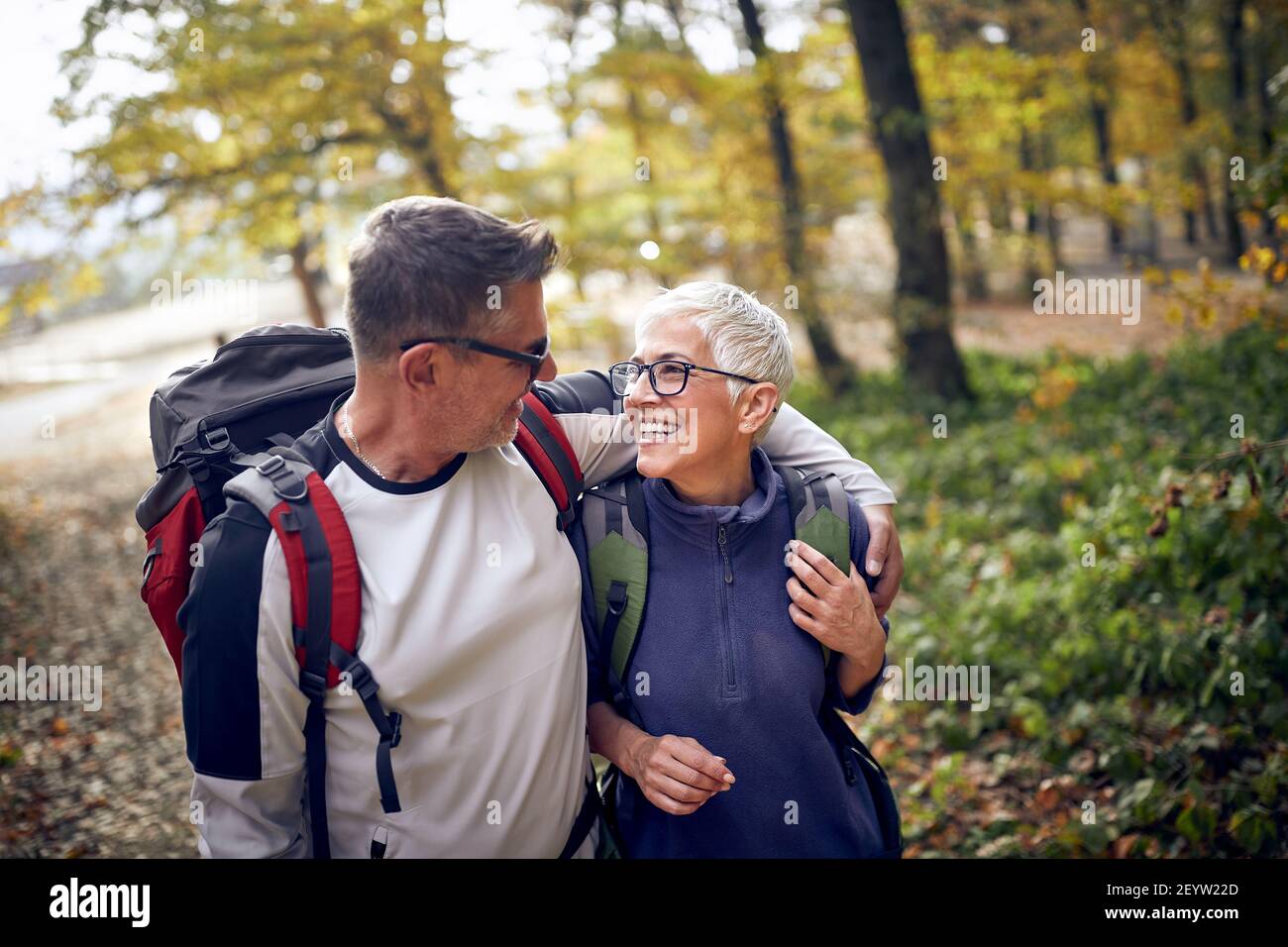 Happy elder couple walking in autumn in nature Stock Photo - Alamy