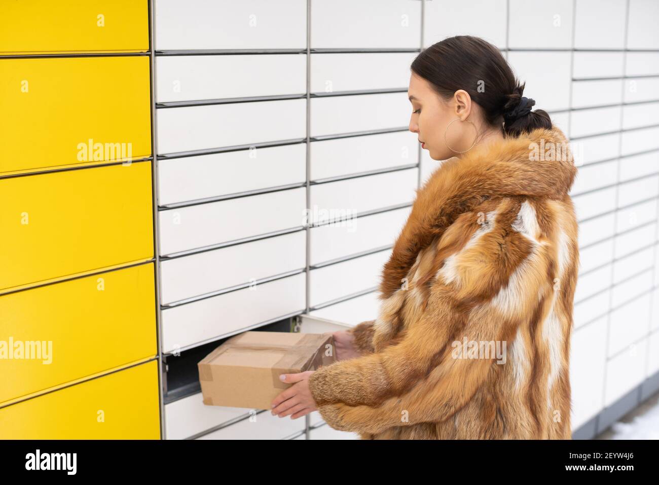 Close-up view of a rich woman picking up a package from a parcel locker ...