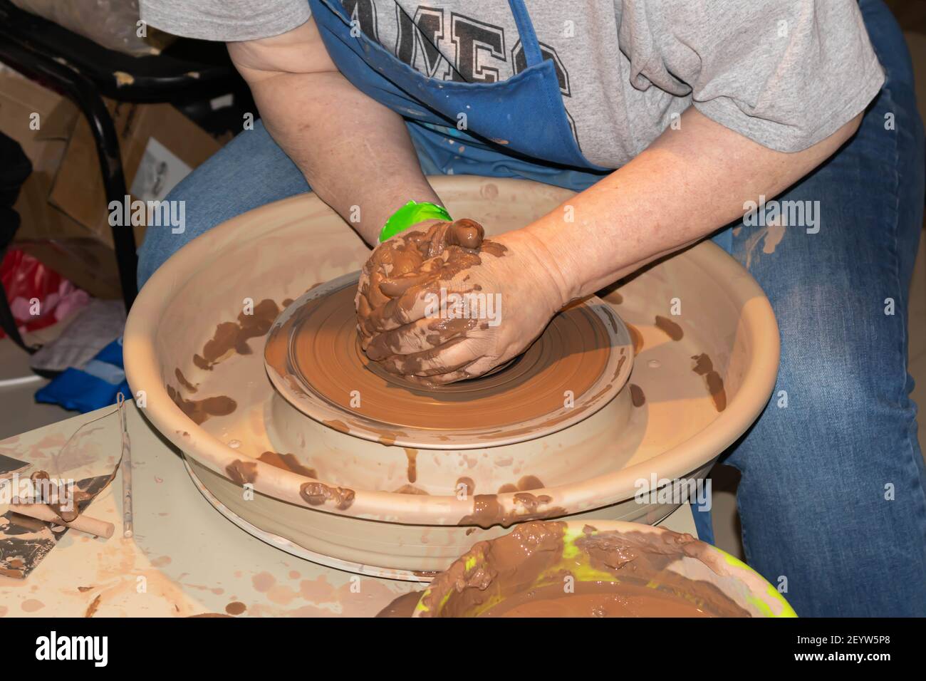 Close-up hands on a potter's wheel make ,mold, utensils from soft clay ...