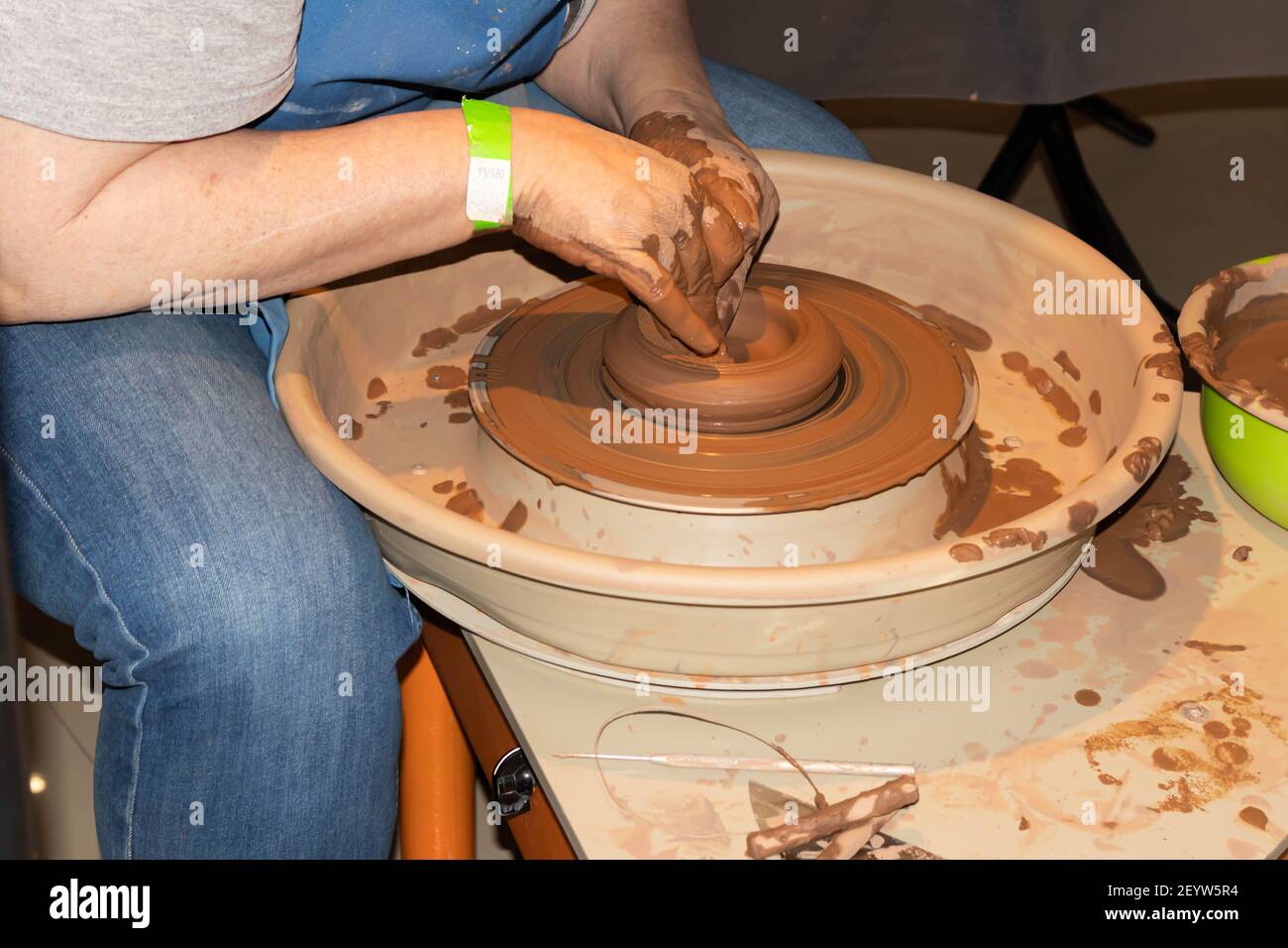 Close-up hands on a potter's wheel make ,mold, utensils from soft clay ...