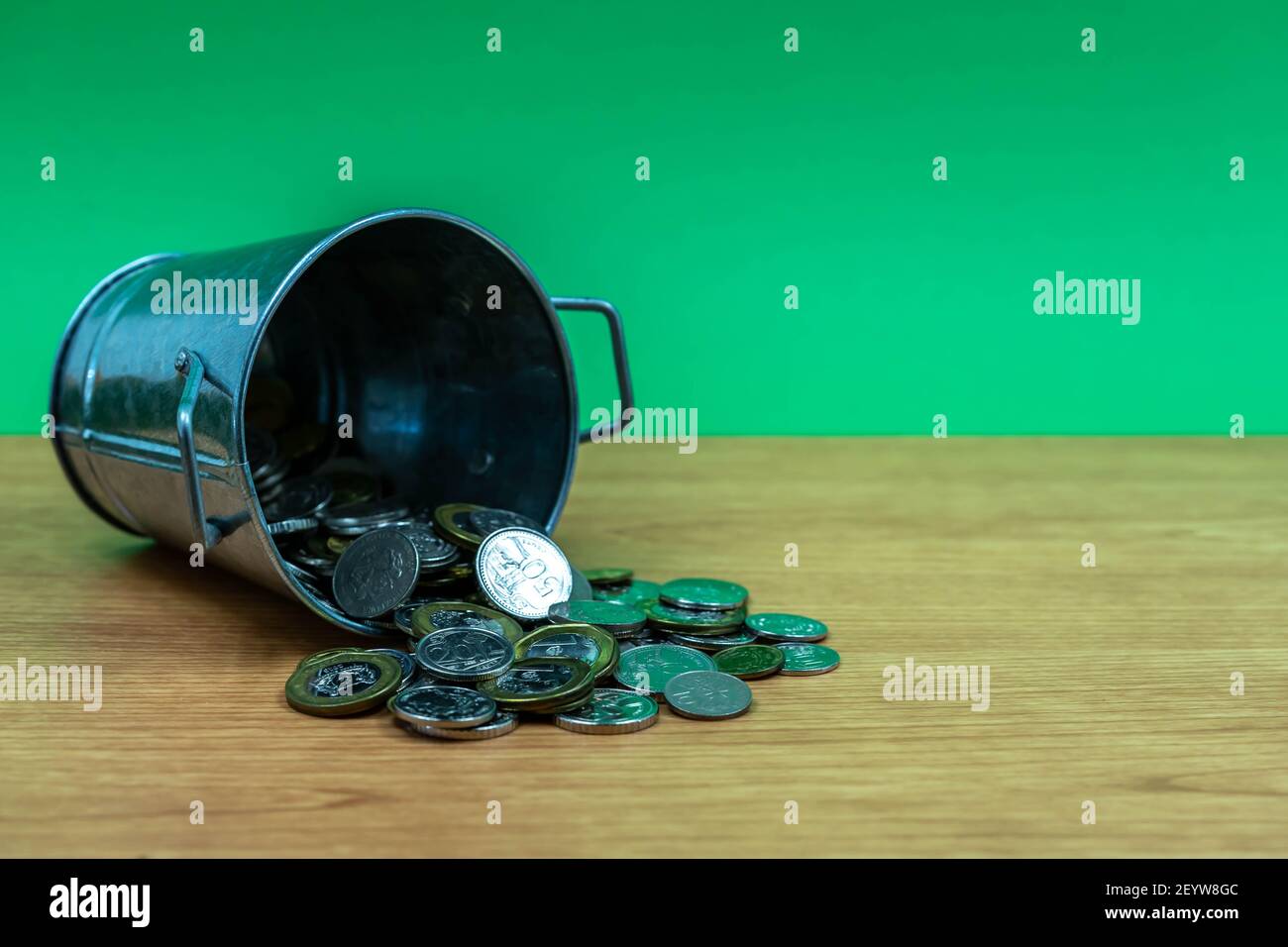 Singapore Dollar silver coins spilling from silver pail. Isolated Stock ...