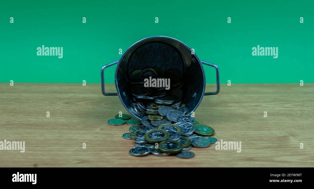 Singapore Dollar silver coins spilling from silver pail. Isolated Stock ...