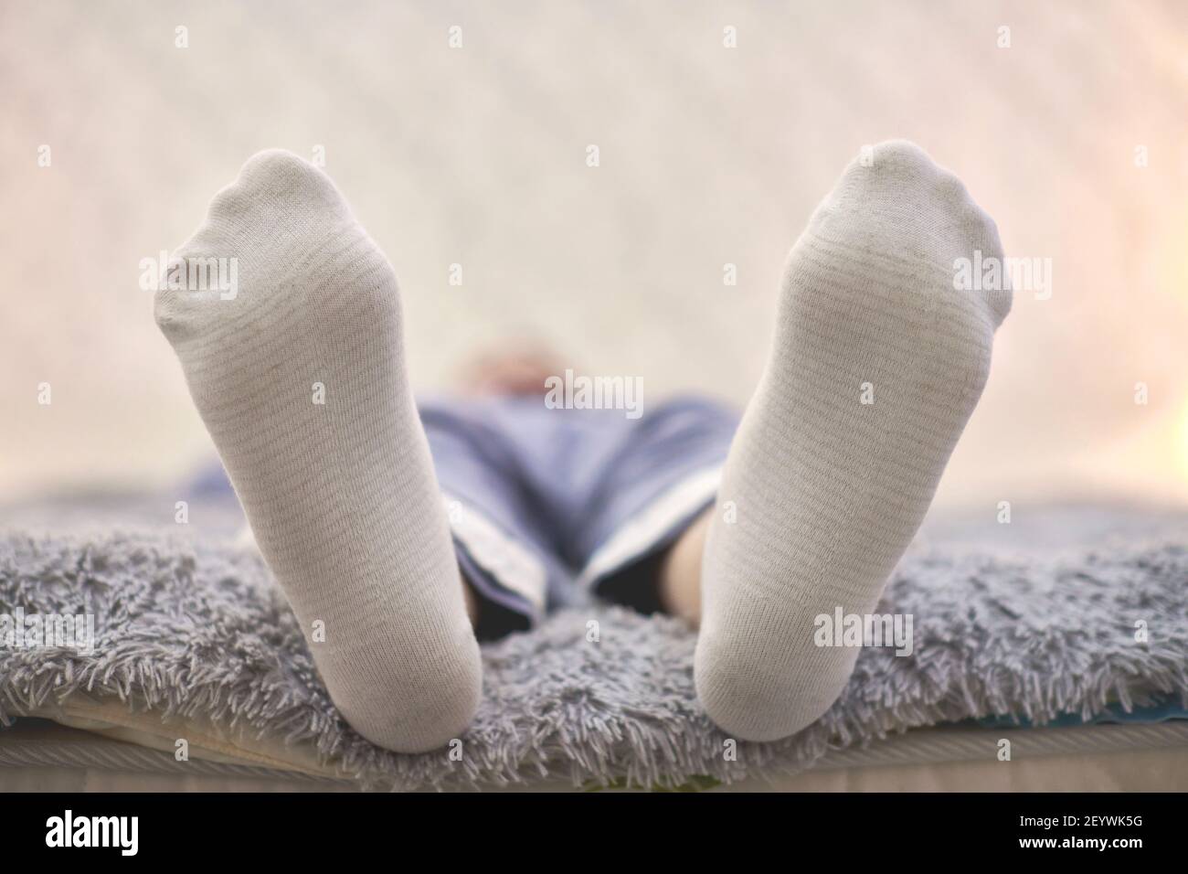 Woman resting on sofa in cozy soft comfortable socks. Female feet in ...