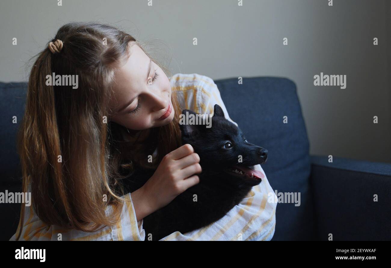 Tween girl playing with puppy at home Stock Photo - Alamy