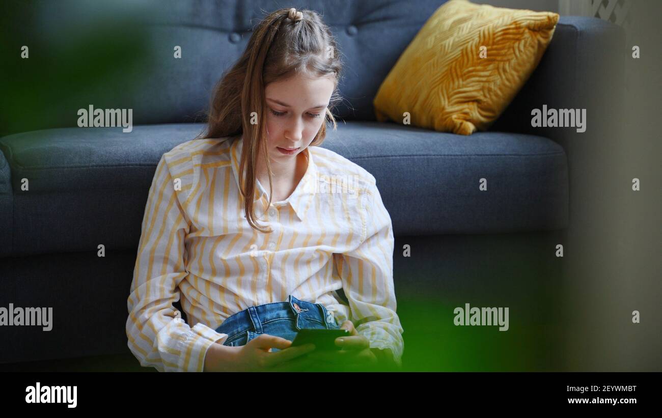 Tween girl with smartphone at home Stock Photo - Alamy