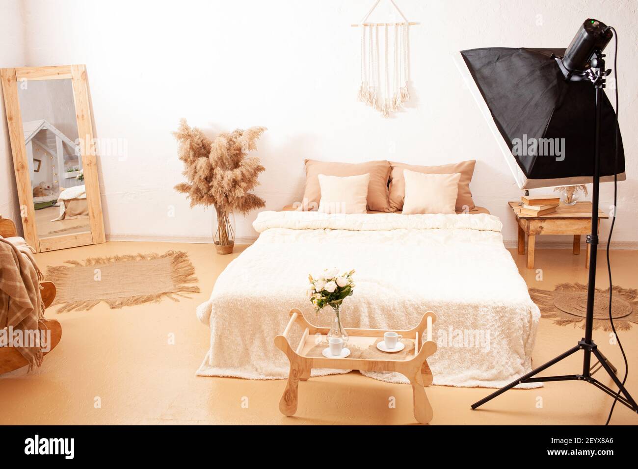 Interior photo studio, beige brown white. Bedroom. Bed, pampas, flower ...