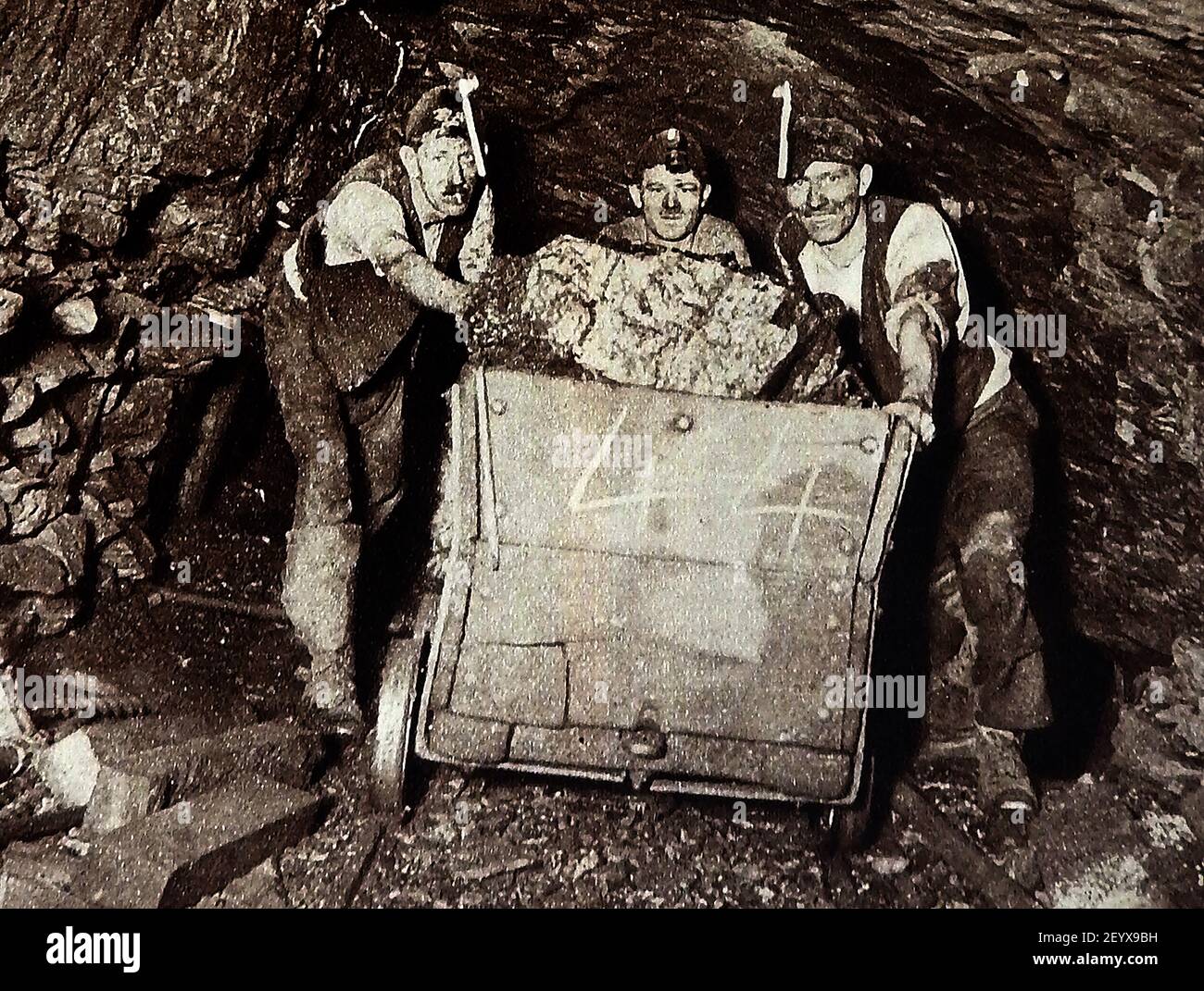 An old photograph (circa 1940's) showing coal miners wheeling a truck ...