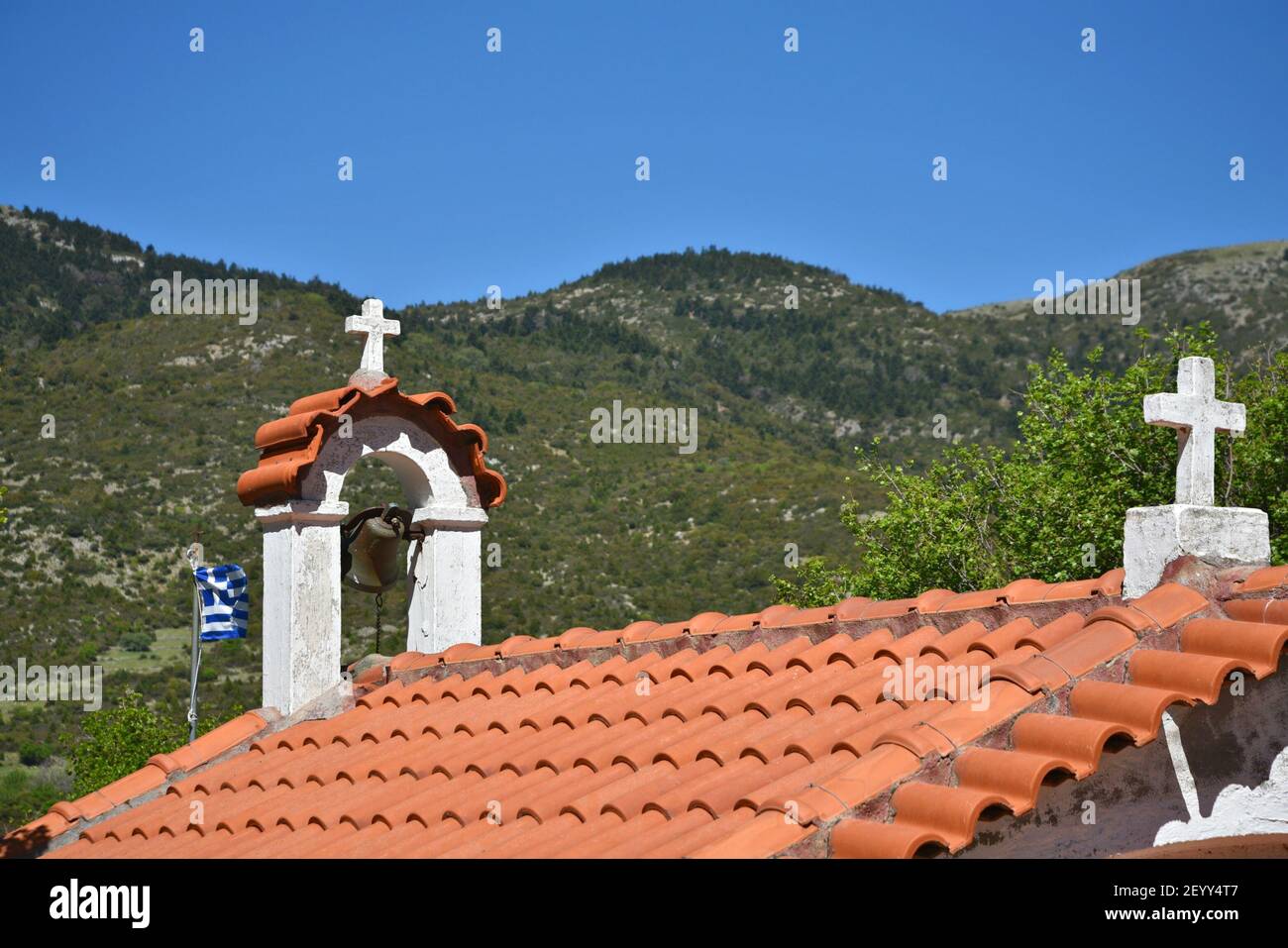 Traditional Greek Orthodox chapel with a red clay tile rooftop and a ...