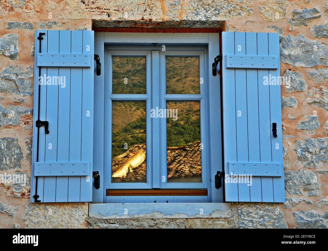 Blue wooden window with shutters on a stone wall in Limeni, Lakonia ...