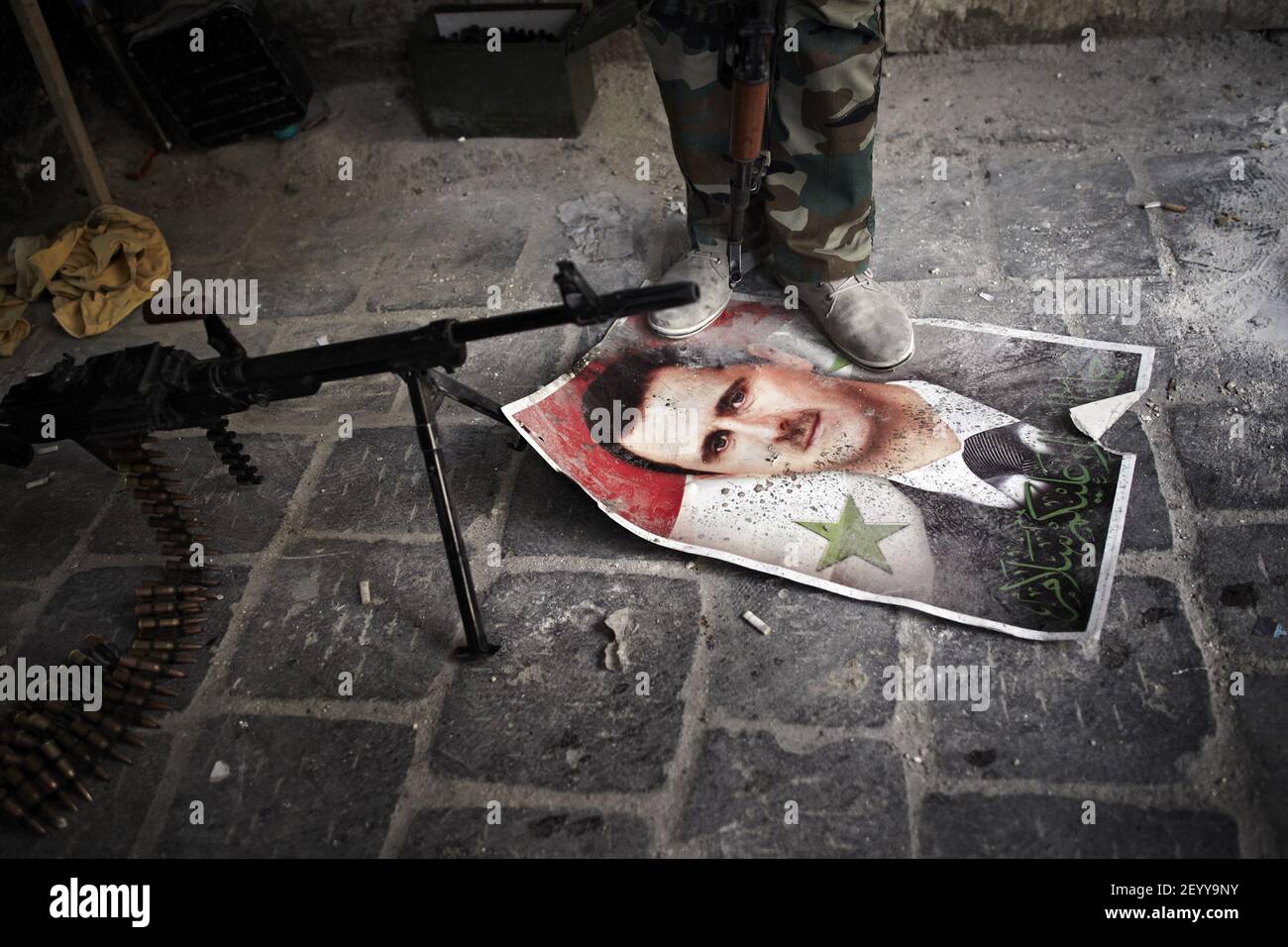 2 October 2012 - Aleppo, Syria - FSA fighter stands on a poster ...