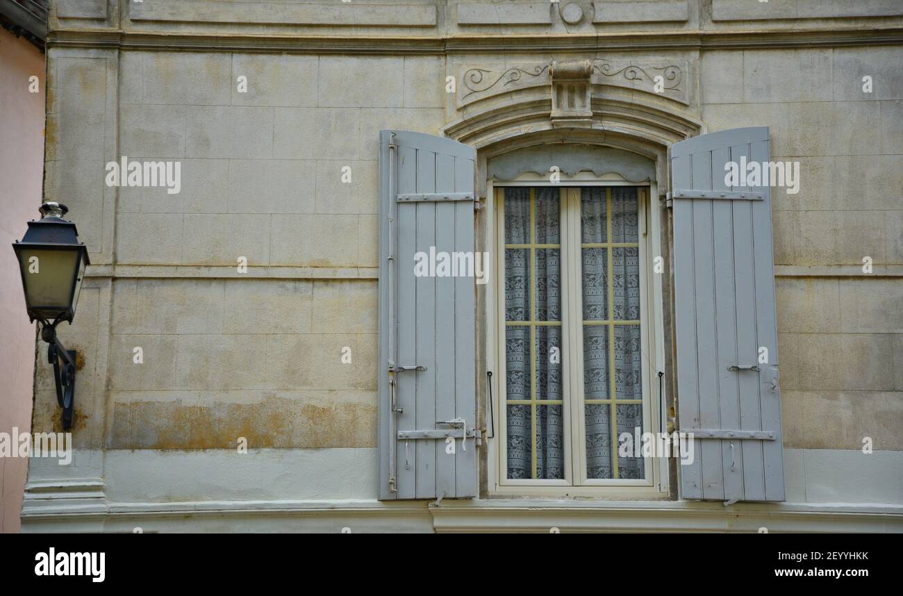 Old Provençal house facade with grey blue wooden window shutters on a ...