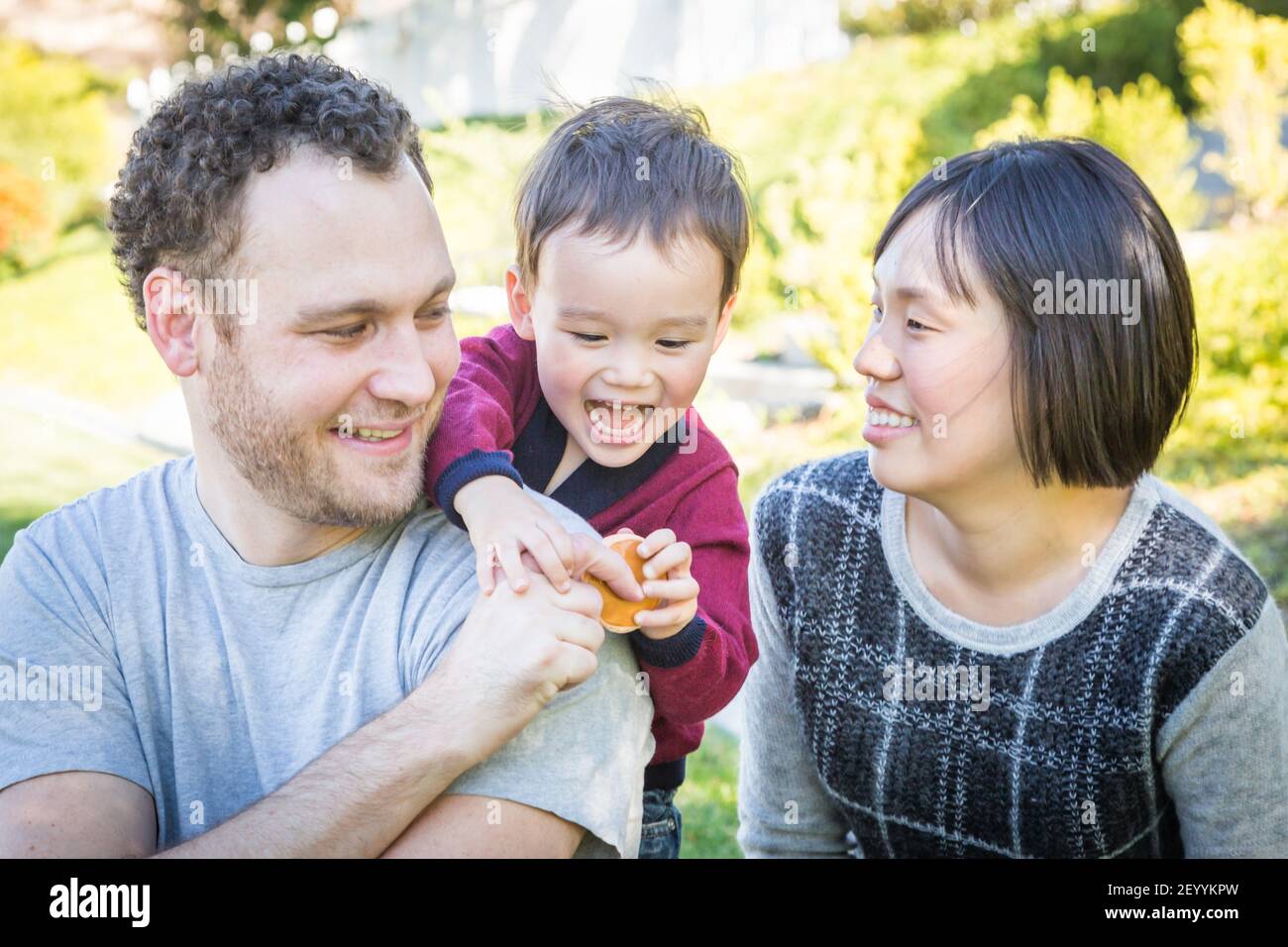 Happy Mixed Race Family Having Fun Outside on the Grass Stock Photo - Alamy