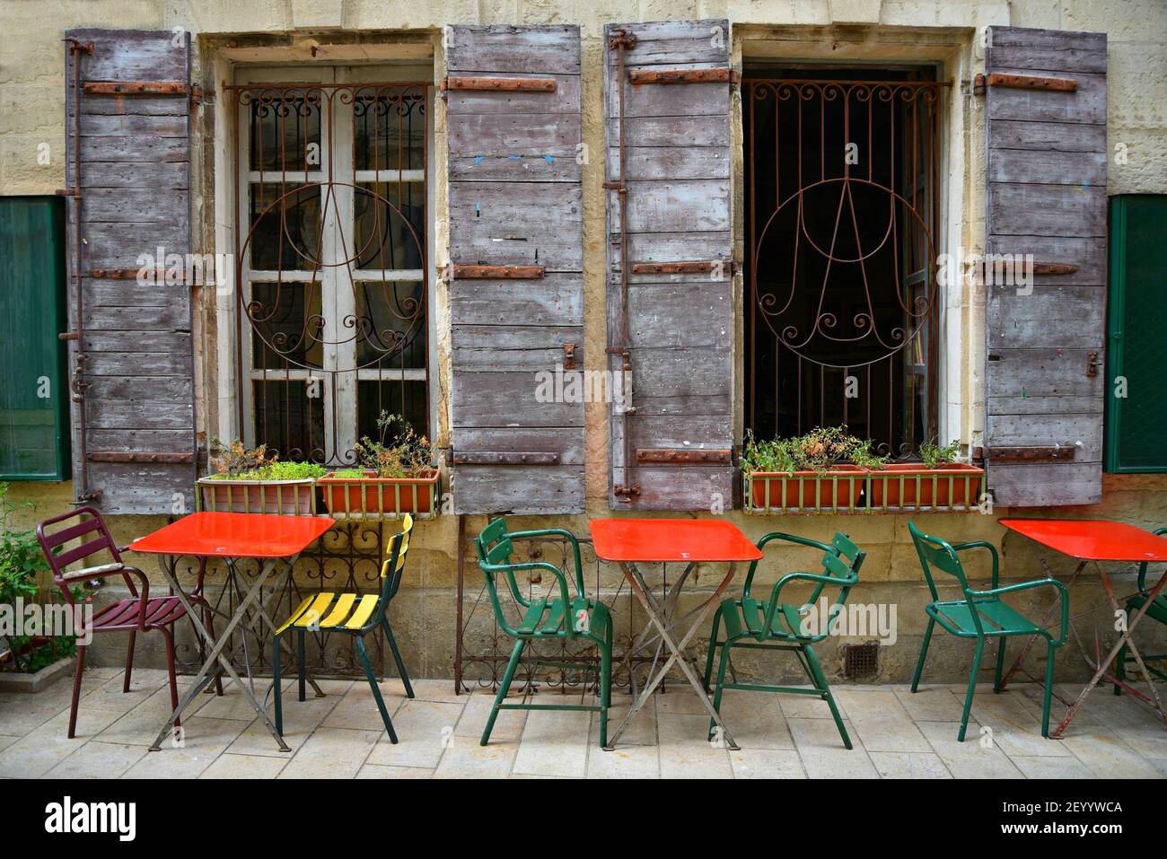 Traditional Provençal café facade with weathered wooden window shutters ...