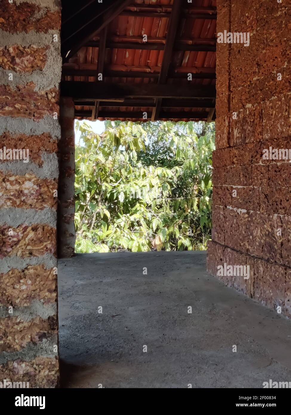 A building's walls made out of red laterite rocks covered with a clay ...