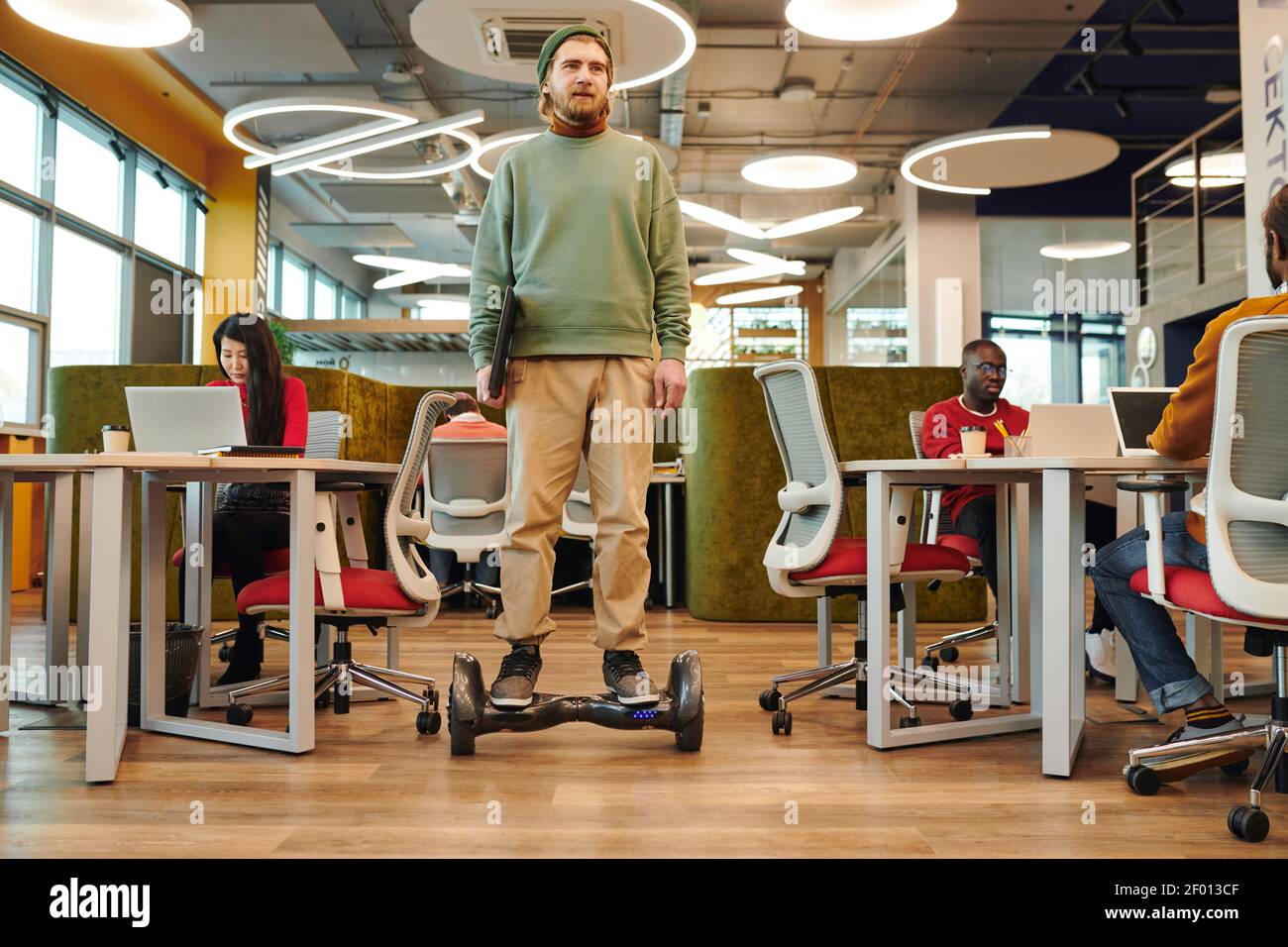 Young contemporary businessman on gyroscope moving along large open ...