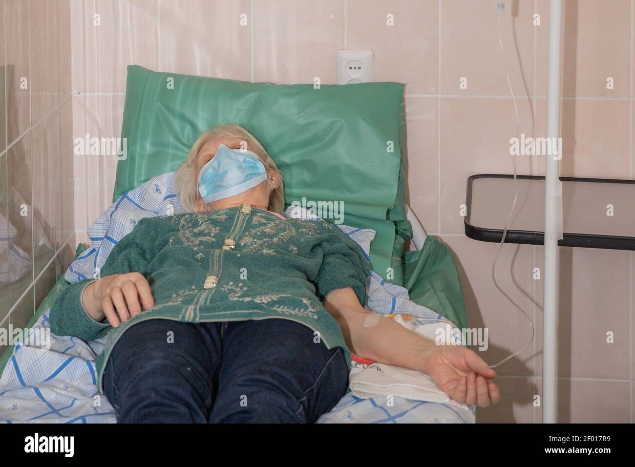 02 march 2021, omsk, russia.old woman with saline solution in hospital ...