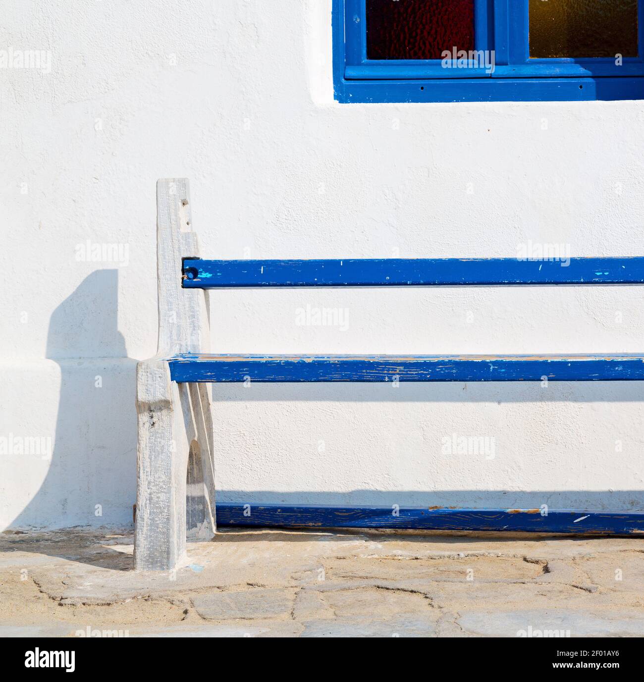 Chair in the greece island of paros old bench near a brick antique wall ...