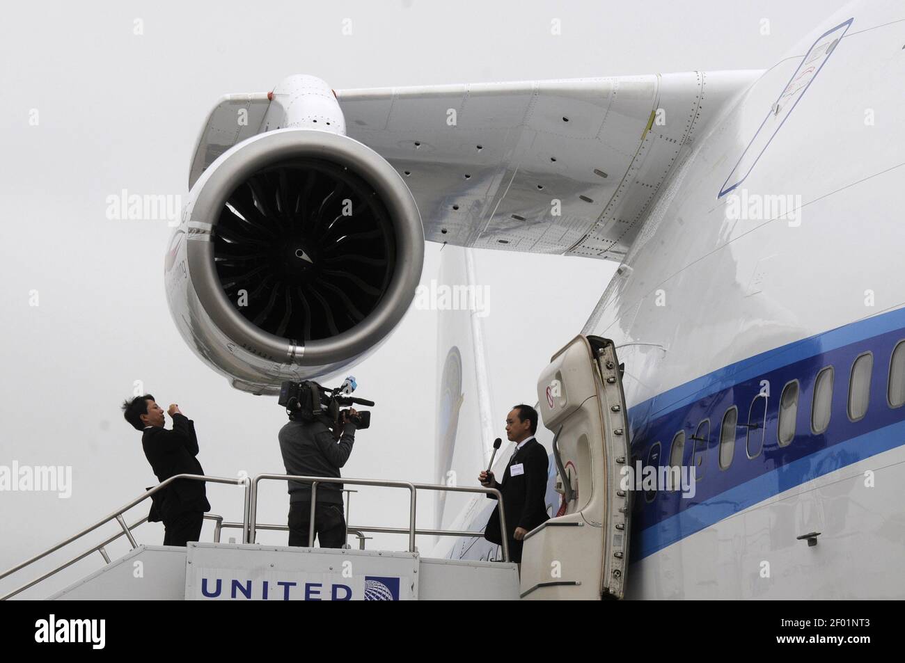 A Japanese film crew stands below a Pratt & Whitney test engine mounted ...