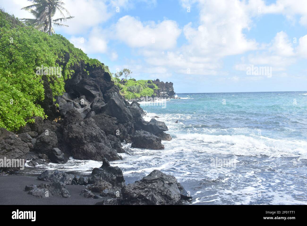 The landscape of beautiful ocean waves hitting the black volcanic rocky ...